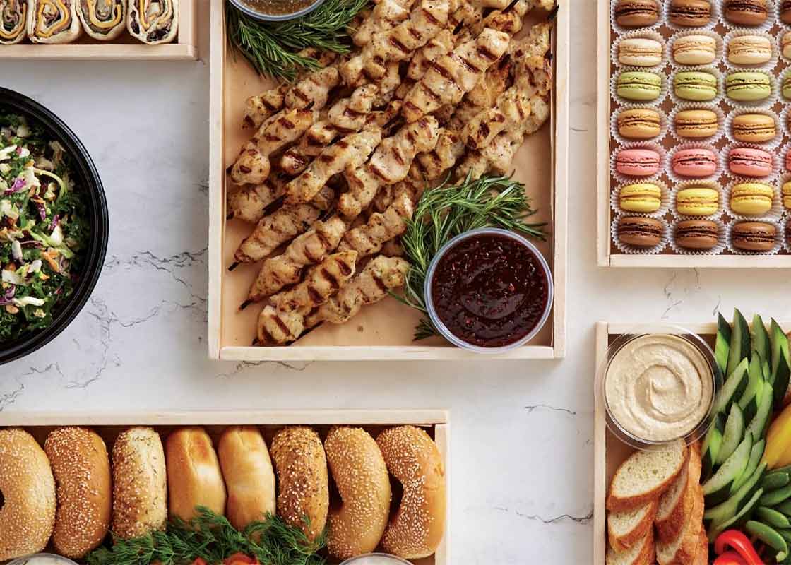 Image is of catering trays containing a bowl of salad, tray of ...